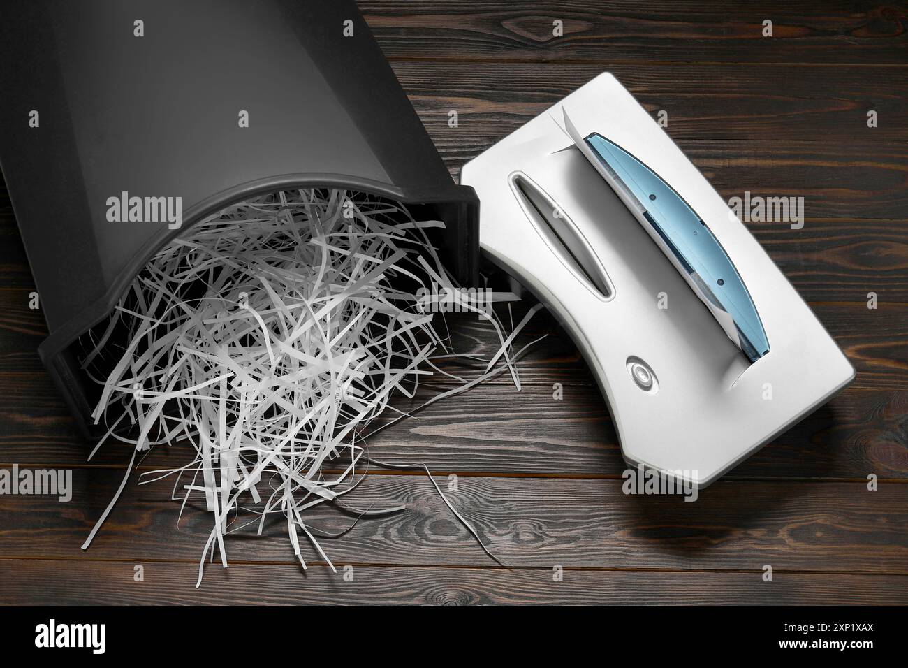 Shredder, black bin and paper strips on wooden table, flat lay Stock ...