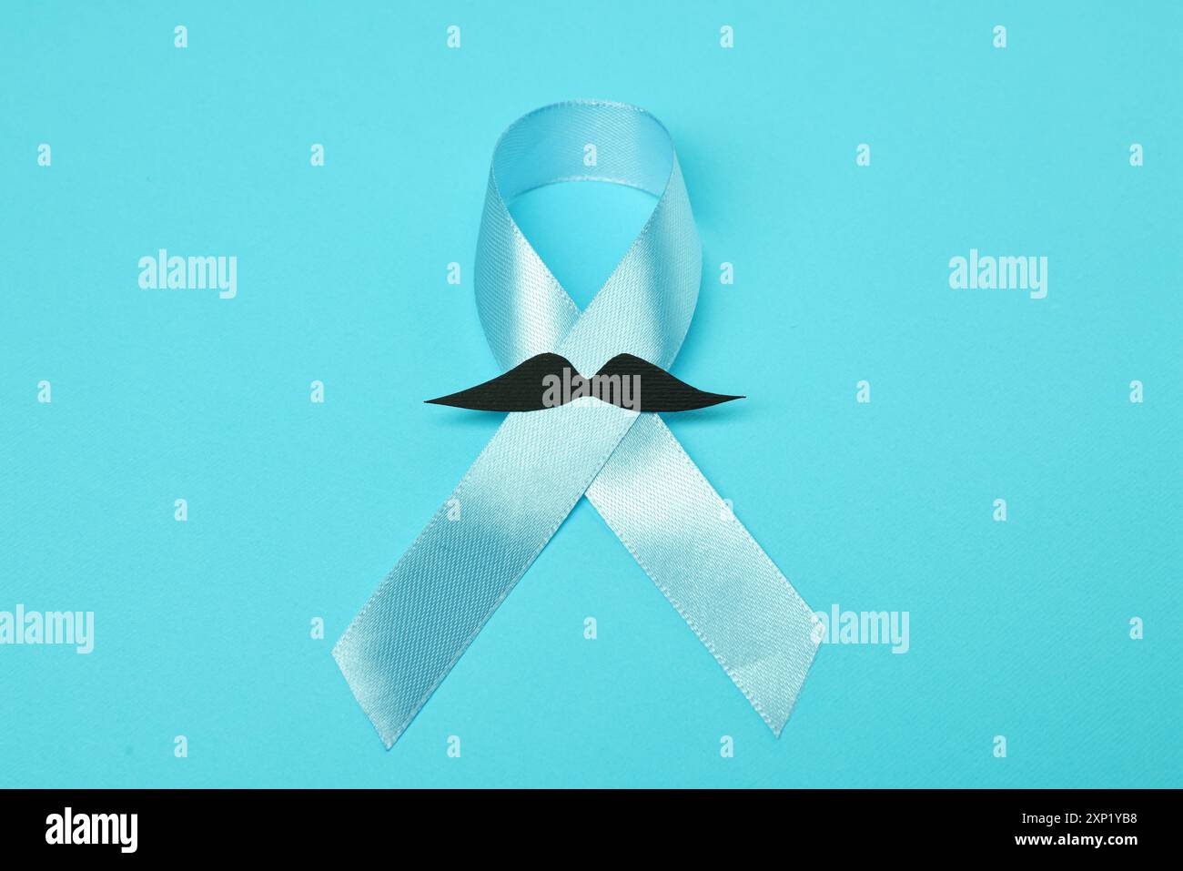 Light blue ribbon and fake mustache on color background, top view ...