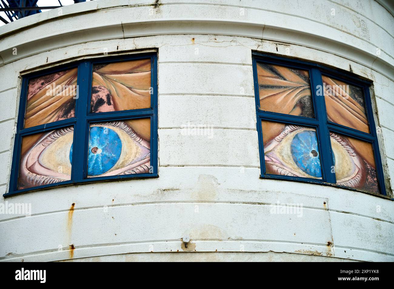 Large evil eyes looking out from upstairs windows Stock Photo - Alamy