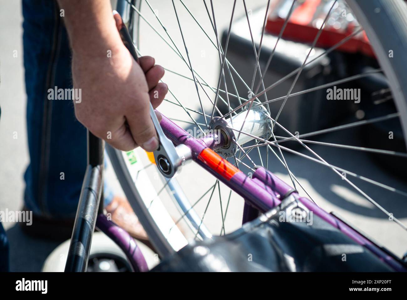 Hands repairing a wheelchair with a wrench, showcasing maintenance ...