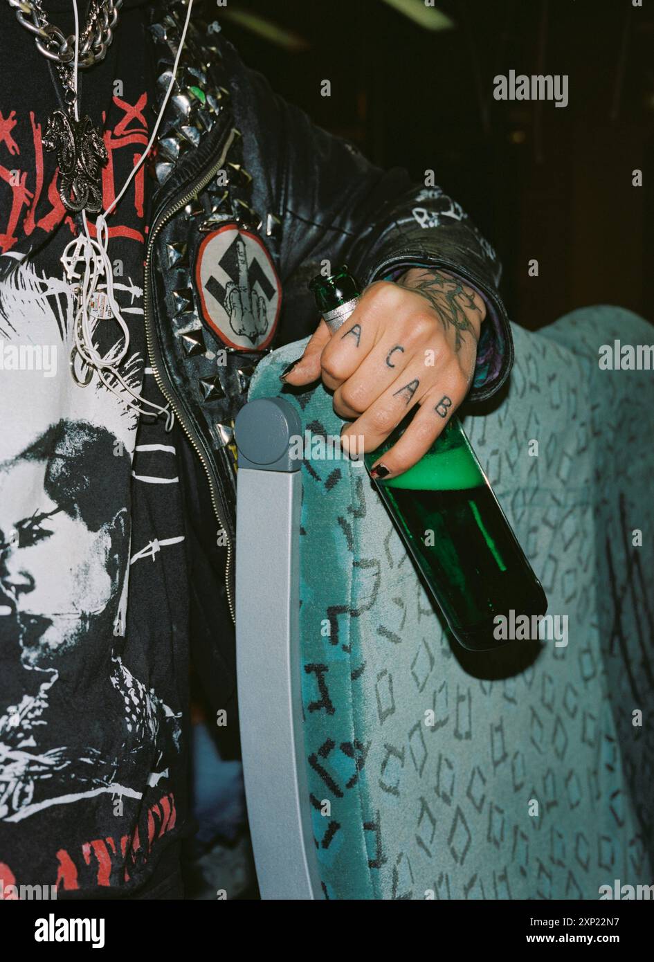 A detailed shot of a punk wearing a studded leather jacket, holding a ...