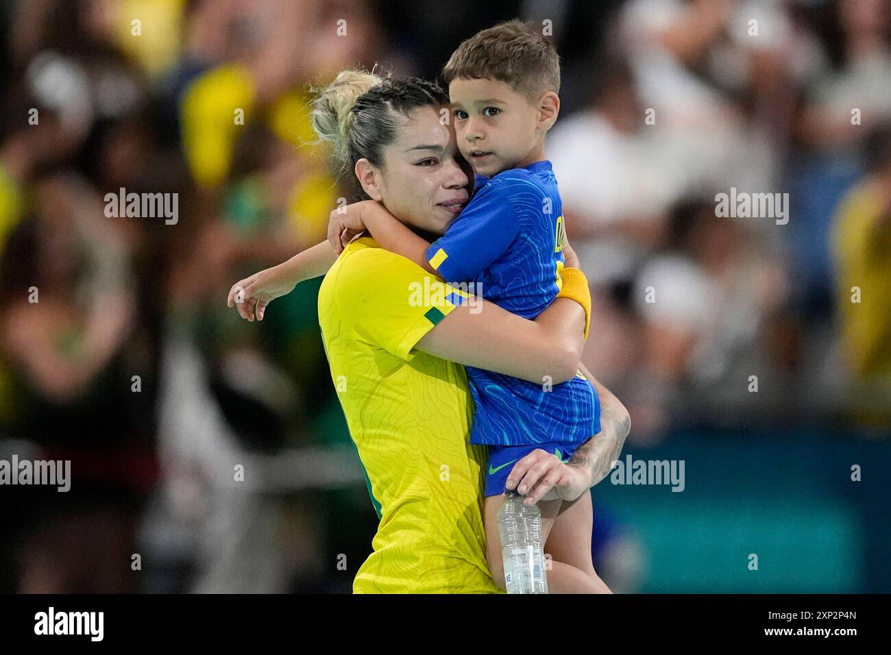 Jessica Quintino, of Brazil, embraces her son Zion after winning ...