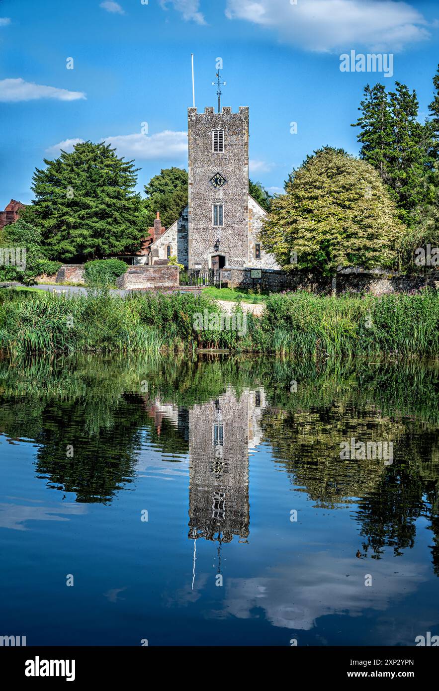 A reflection of St Mary's church tower in Buriton pond on a bright ...