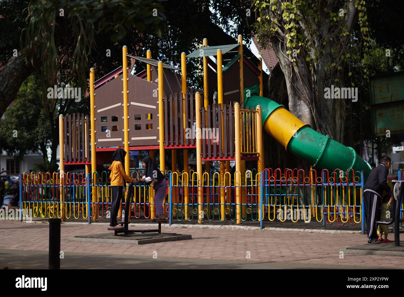 Children playing in a playground in an open public space in the morning ...