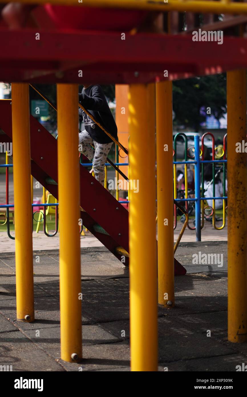Children playing in a playground in an open public space in the morning ...