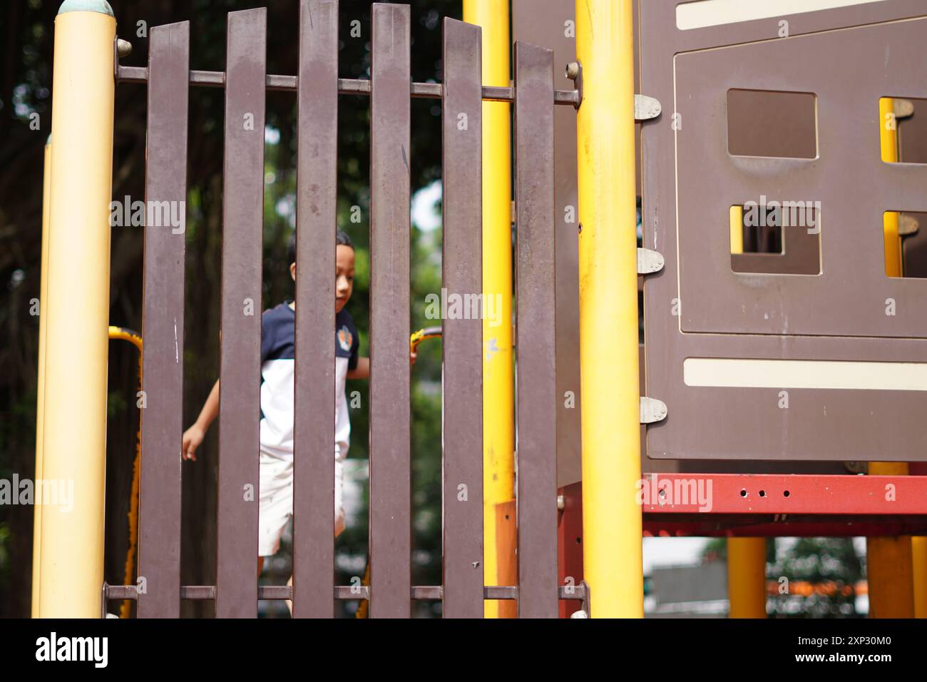 Children playing in a playground in an open public space in the morning ...