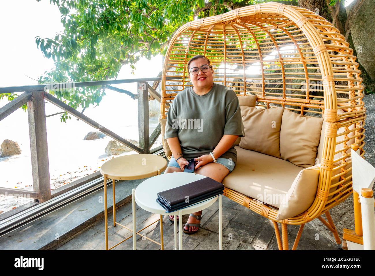 A happy, smiling Filipino lady sat in a wicker chair next to Tanjing ...