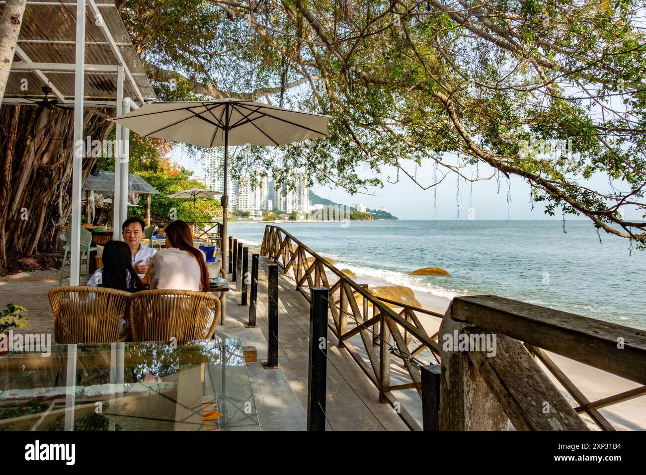 A family sat at a table at a restaurant with views over Tanjing Tokong ...