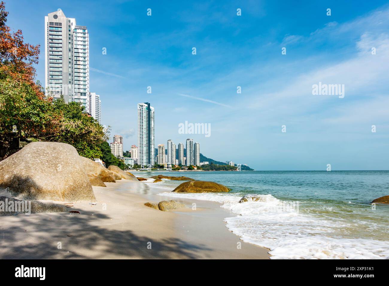 A view along Tanjing Tokong beach in Penang, Malaysia with tall, modern ...
