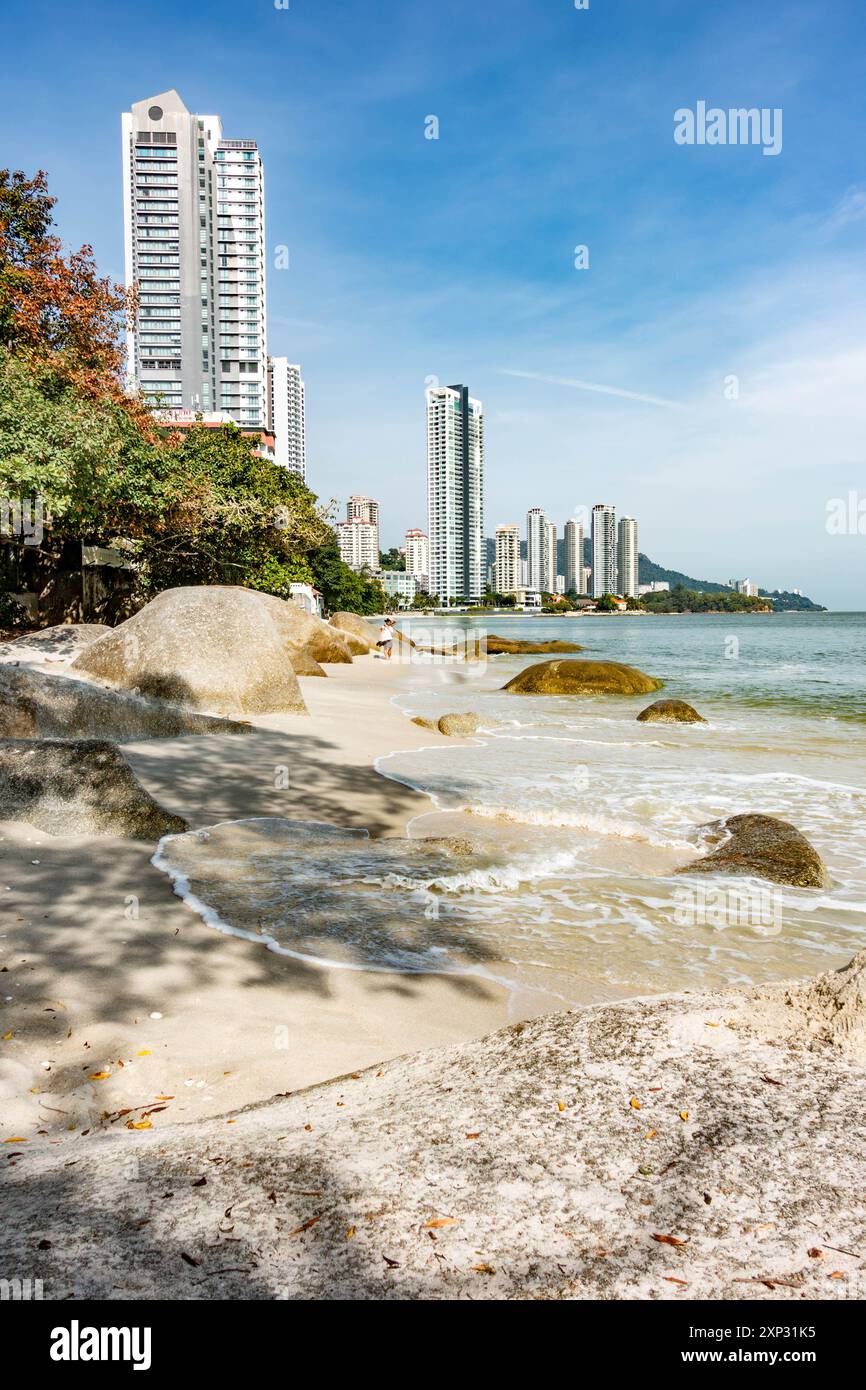 A view along Tanjing Tokong beach in Penang, Malaysia with tall, modern ...