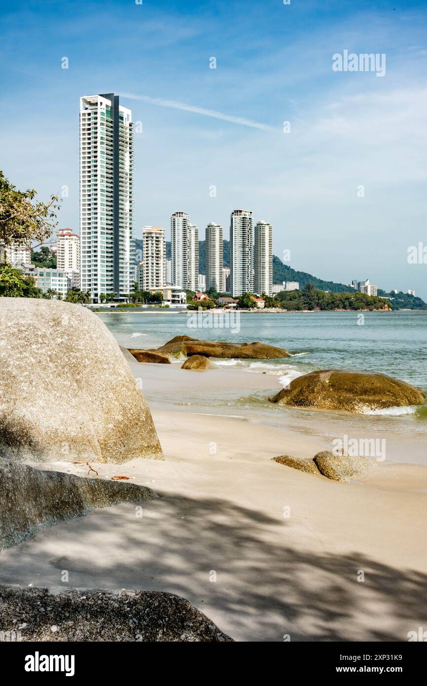 A view along Tanjing Tokong beach in Penang, Malaysia with tall, modern ...