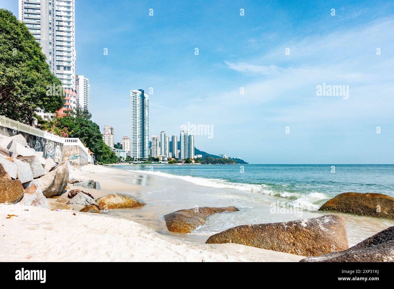 A view along Tanjing Tokong beach in Penang, Malaysia with tall, modern ...