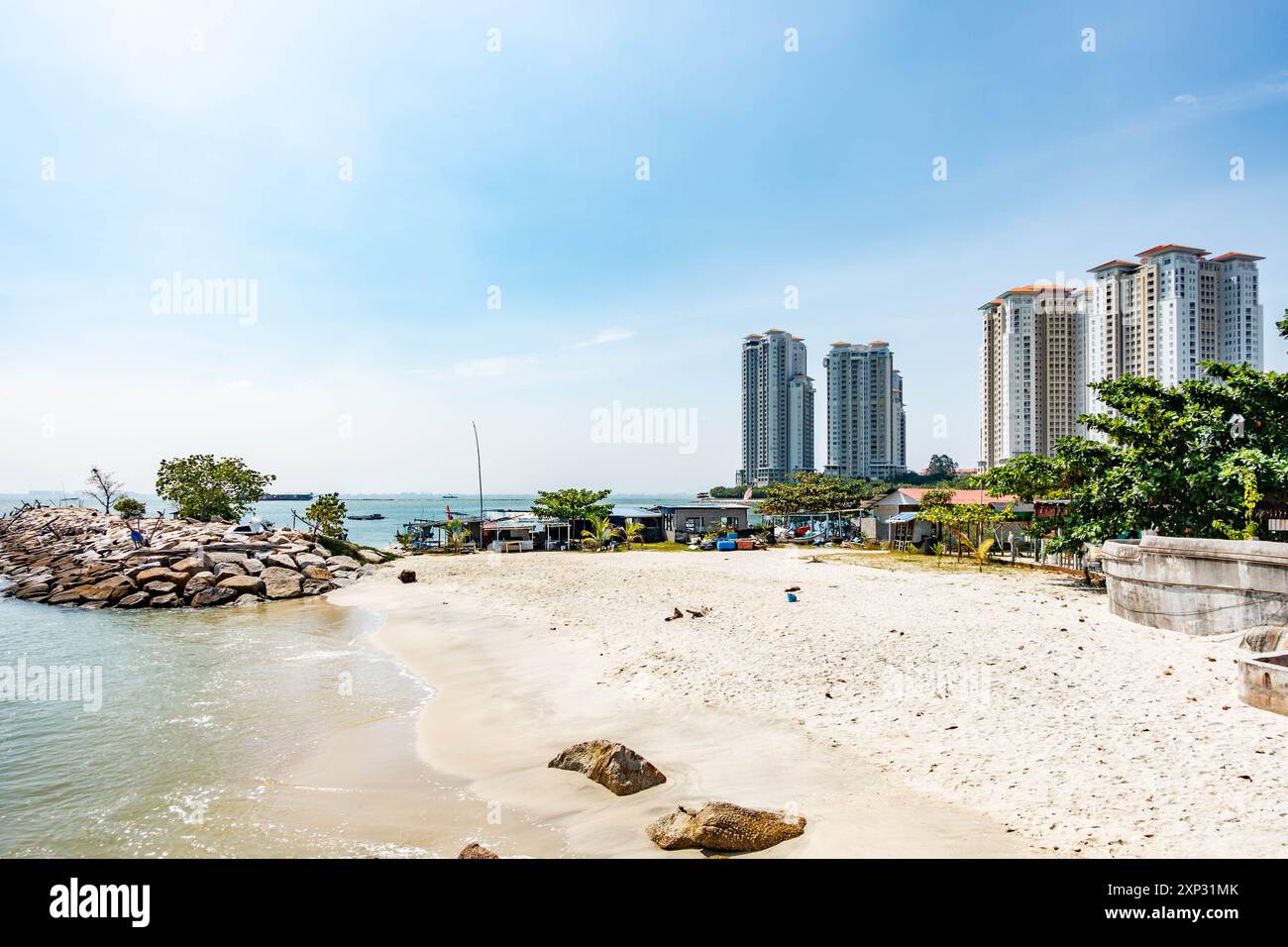 A view along Tanjing Tokong beach in Penang, Malaysia with tall, modern ...