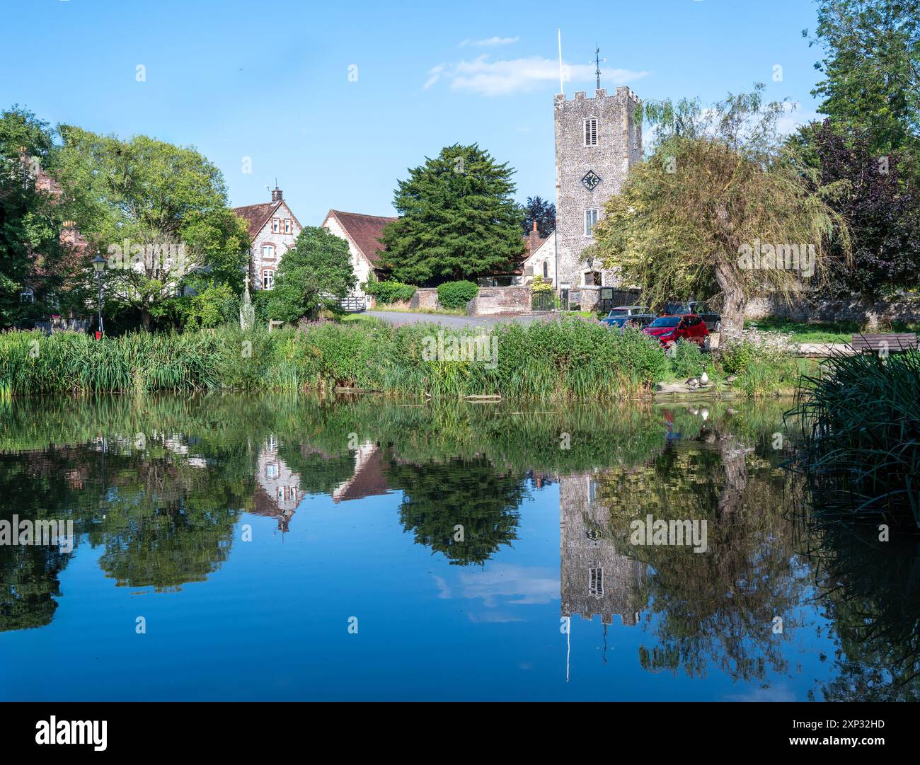 A reflection of St Mary's church tower in Buriton pond on a bright ...