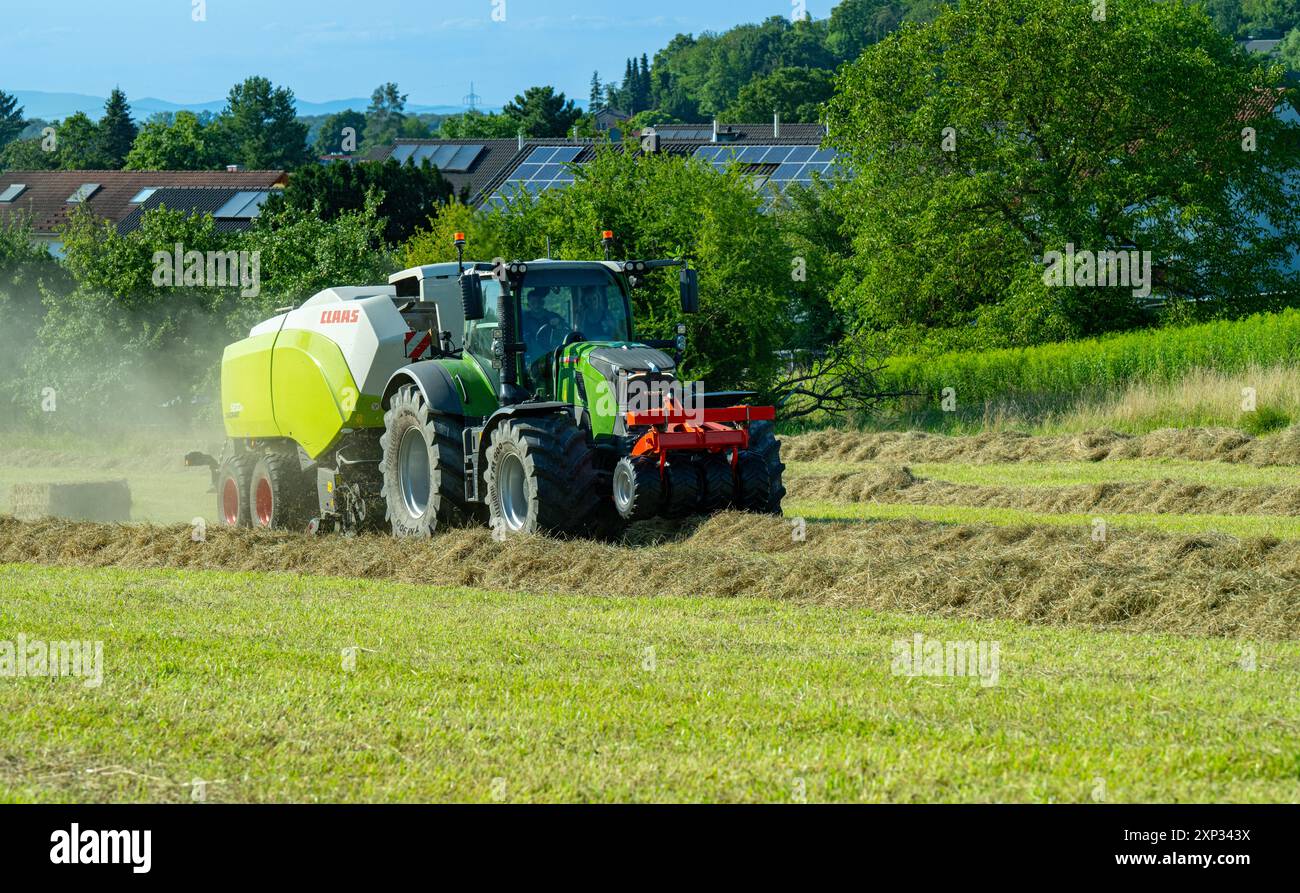 Hay baling, tractor collecting and making hay on a farm Stock Photo - Alamy