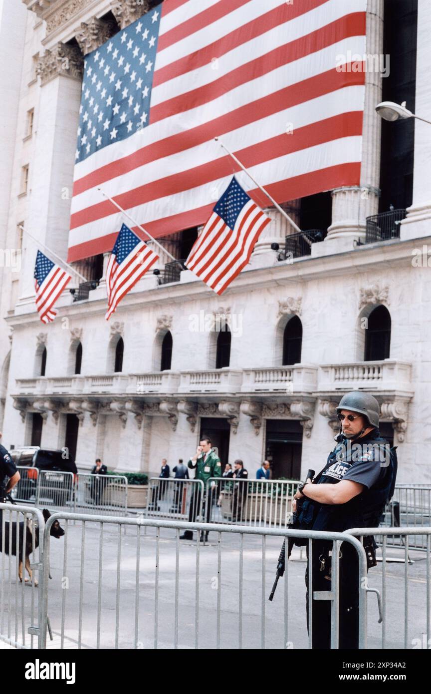 A security guard stands sentinel in front of the Wall Street building ...