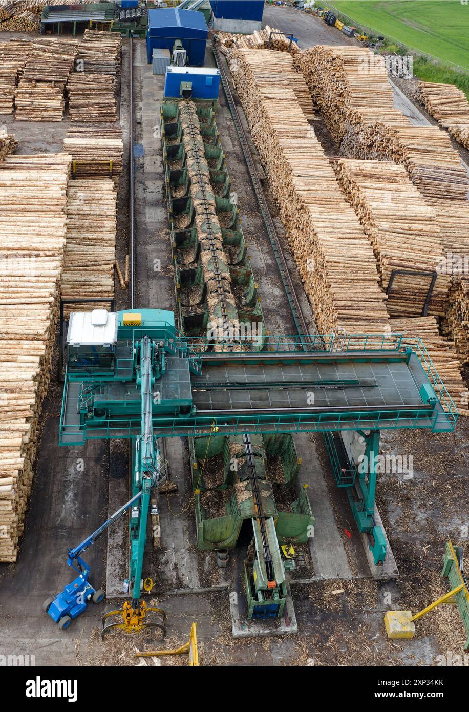 Sawmill with chopped wood logs stacked and machinery Stock Photo - Alamy
