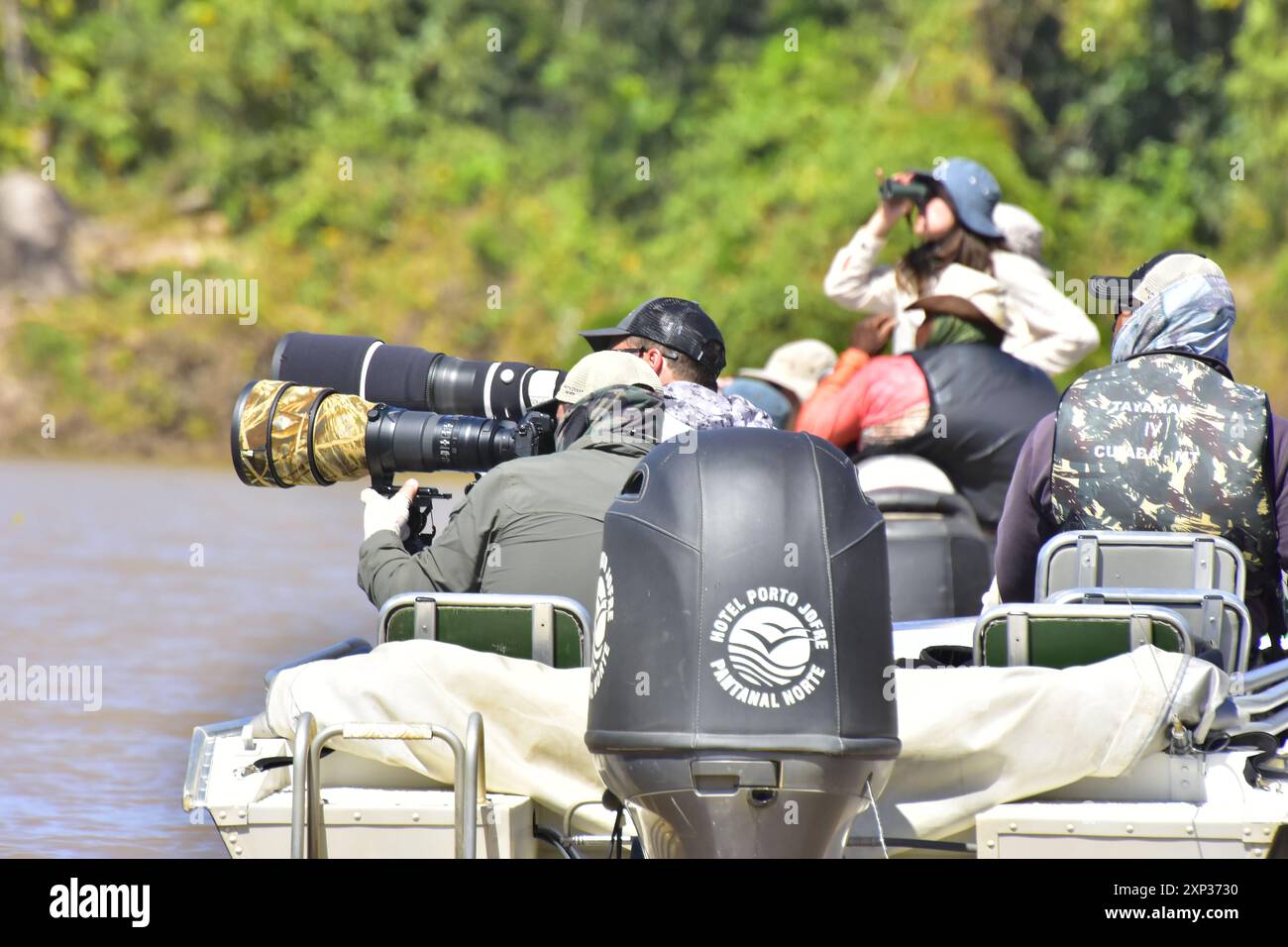 Tourists on the jaguar safari watching jaguars, a popular attraction on Pantanal of Mato Grosso ...