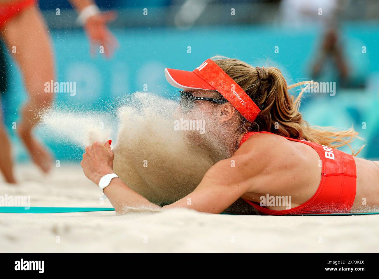 Switzerland's Nina Brunner lands in the sand after diving for a shot in ...