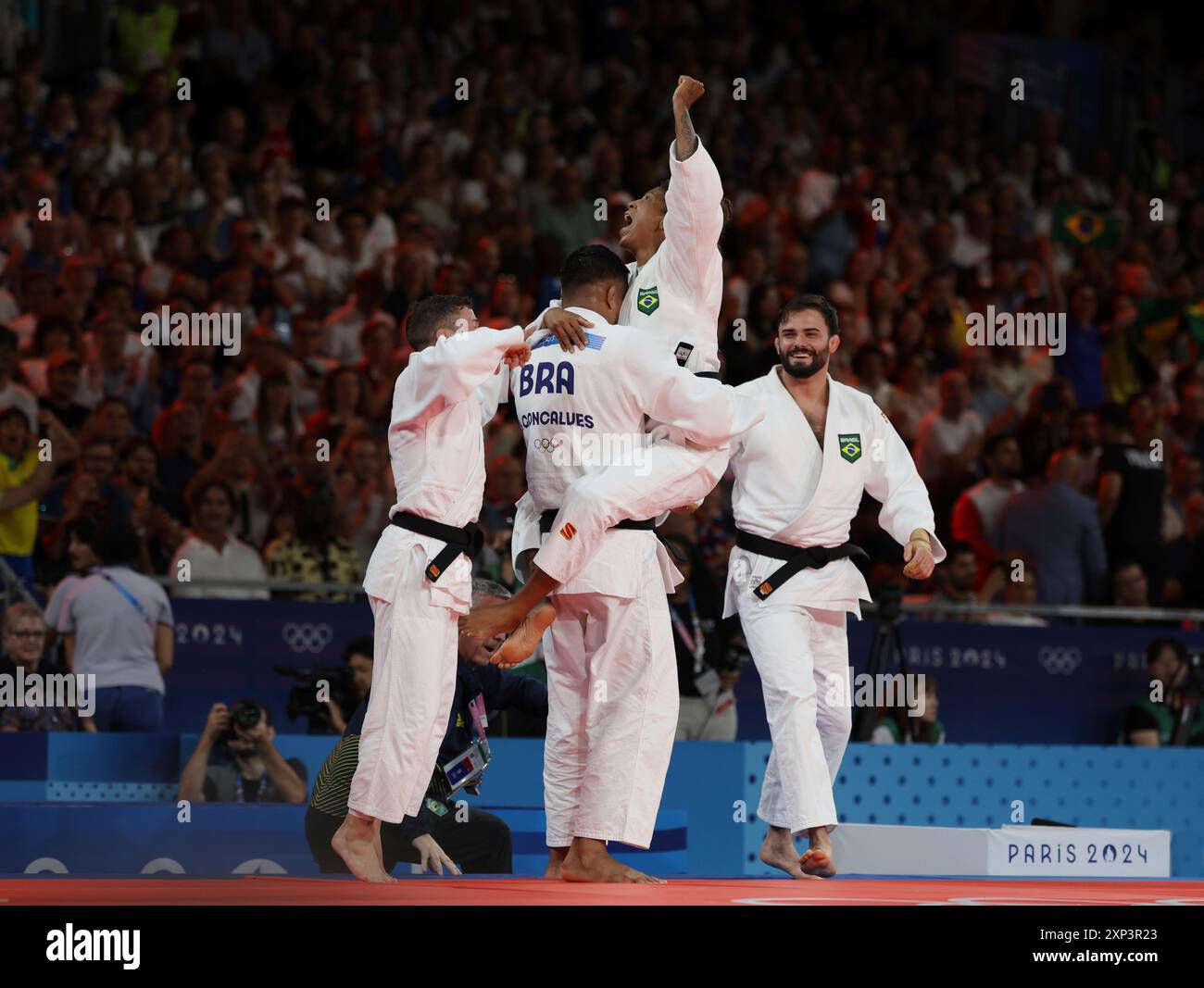 A Brazil team celebrates after winning in the judo mixed team ...