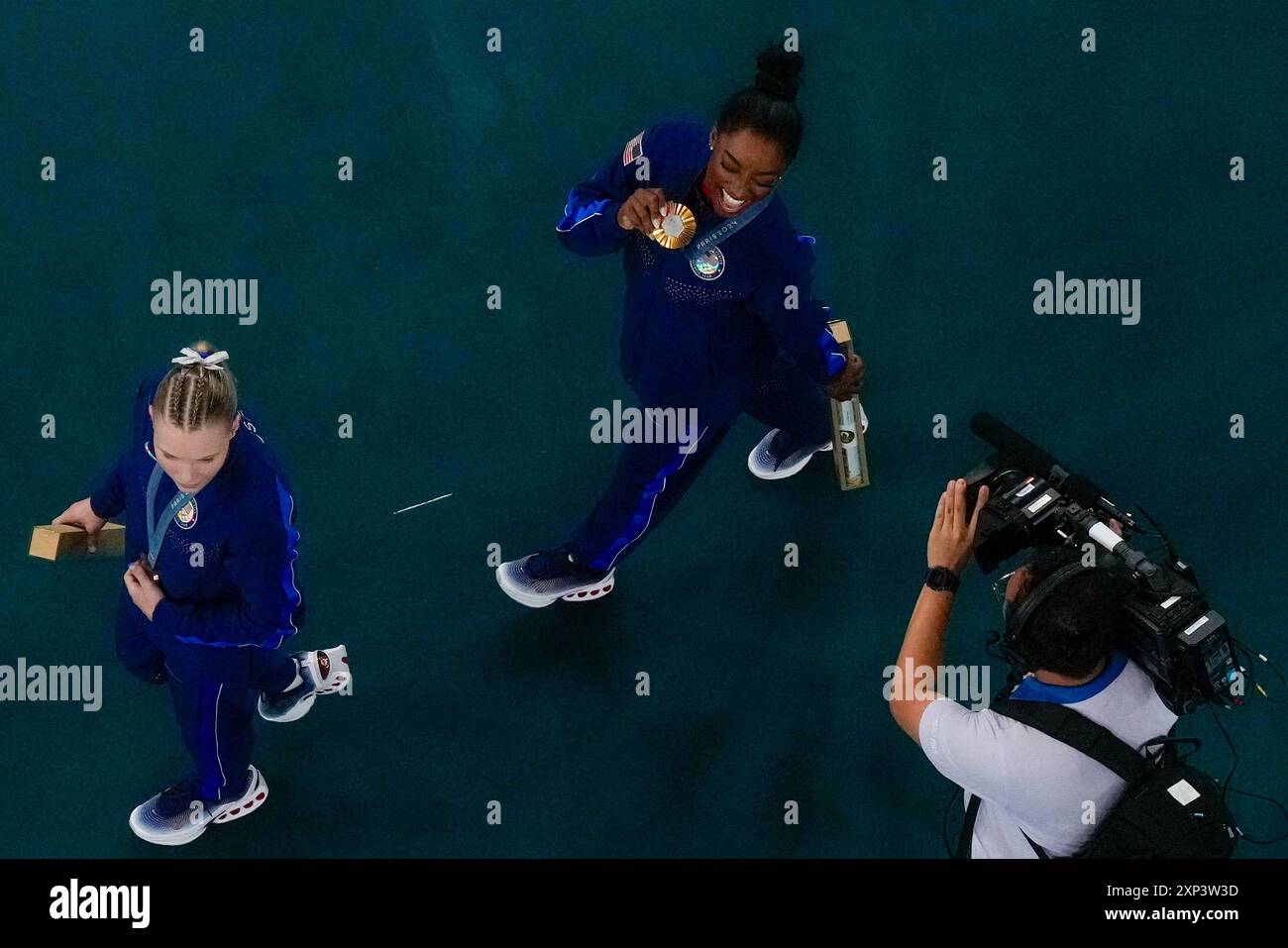 Simone Biles, of the United States, shows off her gold medal after the ...