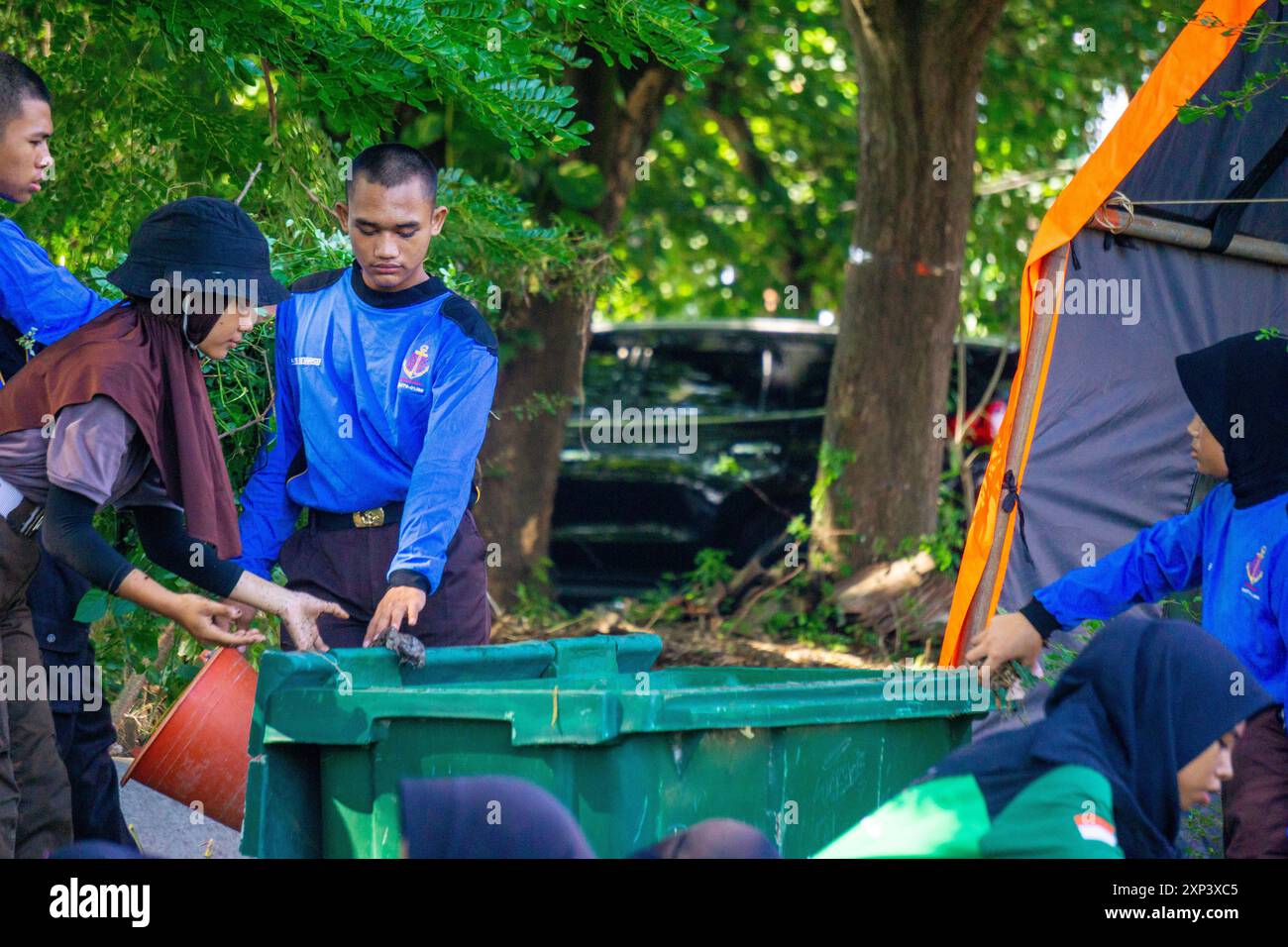 People are cleaning the environment by cleaning up trash and pulling ...