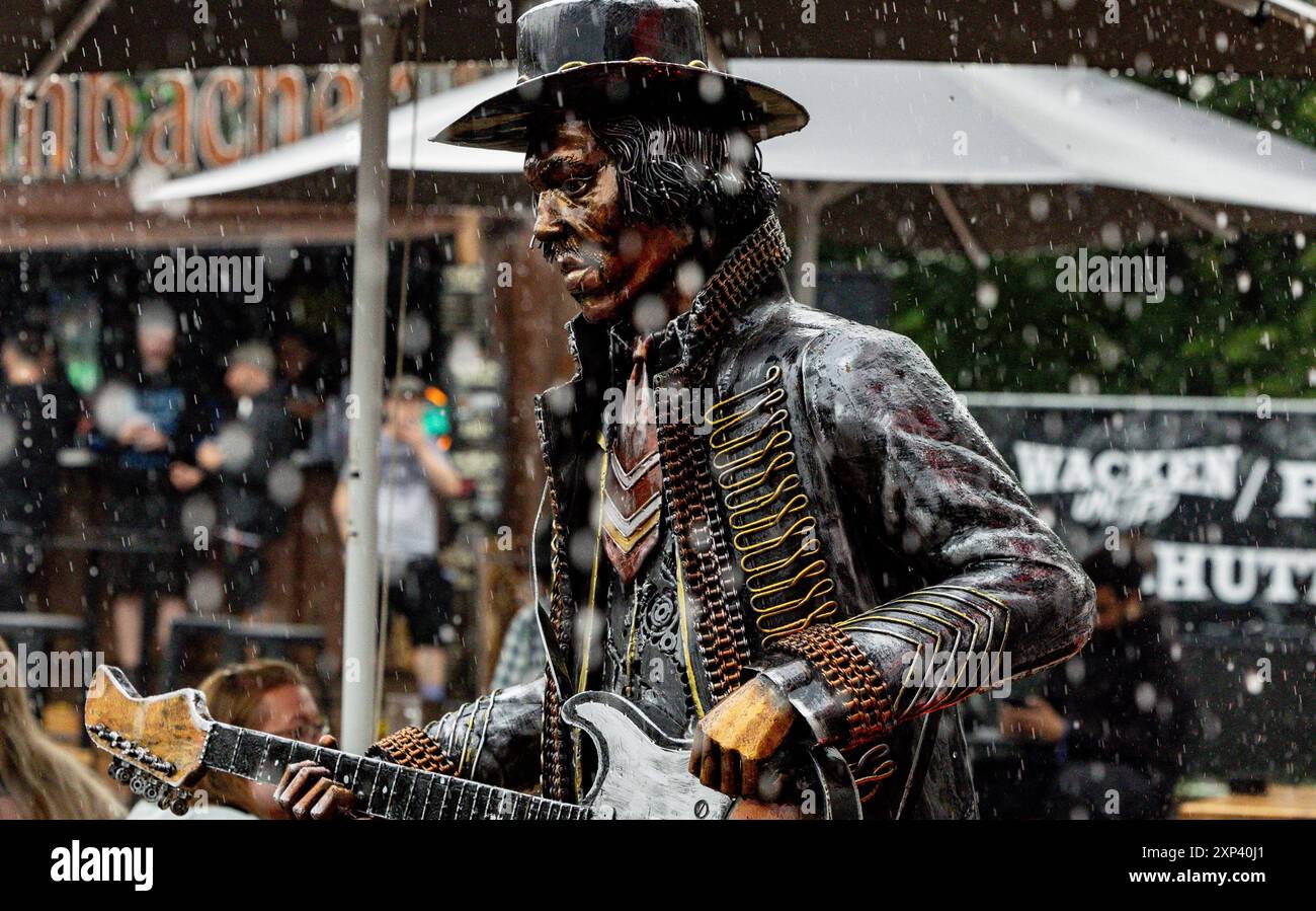 Wacken, Germany. 03rd Aug, 2024. Rain pelting down on a statue of ...
