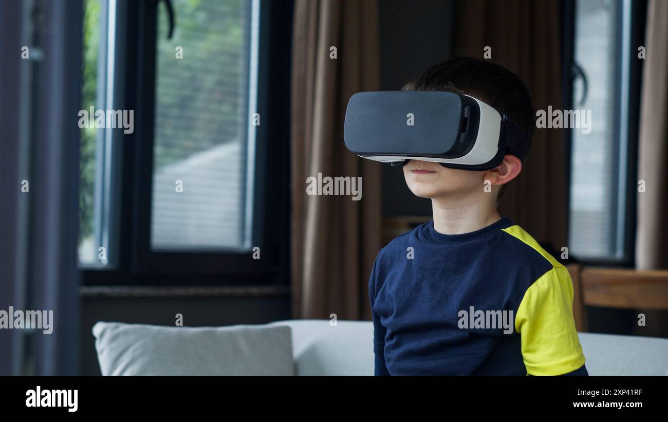 A young boy immersed in a virtual reality experience with a VR headset ...