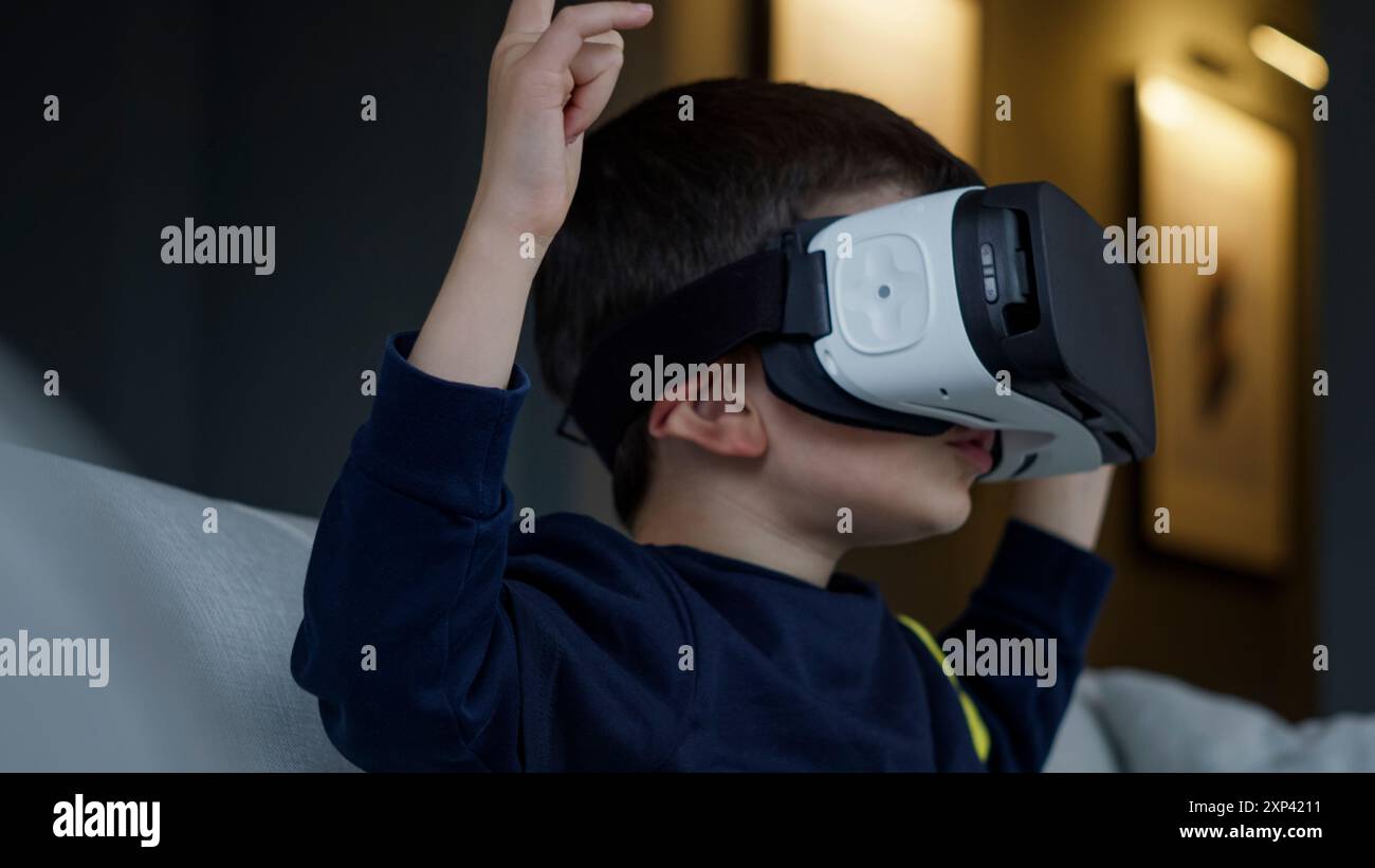 Boy immersed in virtual reality, wearing VR headset and interacting ...