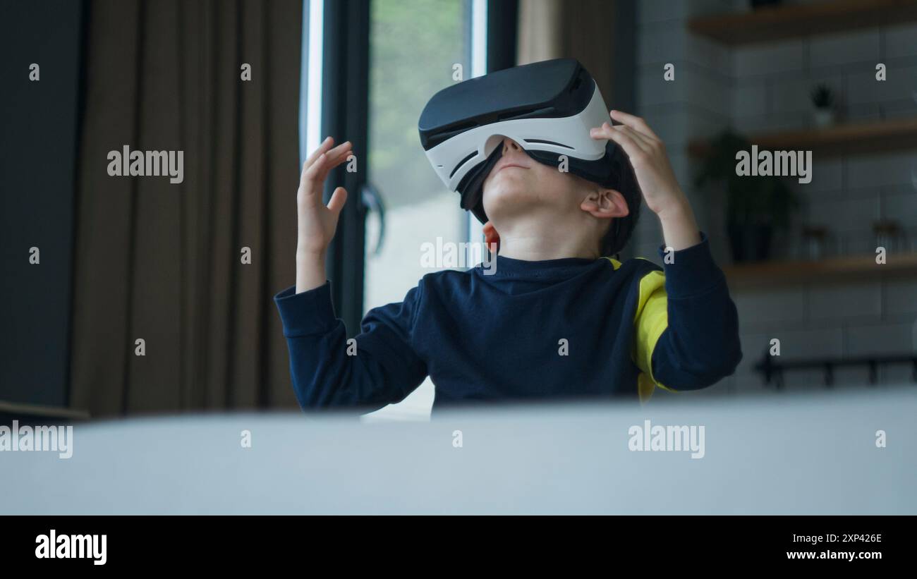 A young boy immersed in a virtual reality experience with a VR headset ...