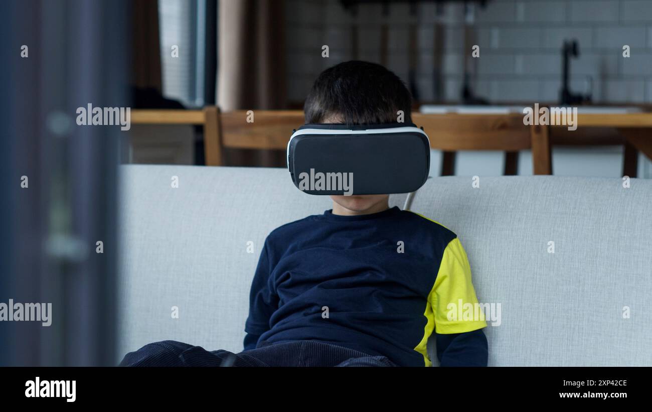 A young boy in a virtual reality experience with a VR headset. The ...