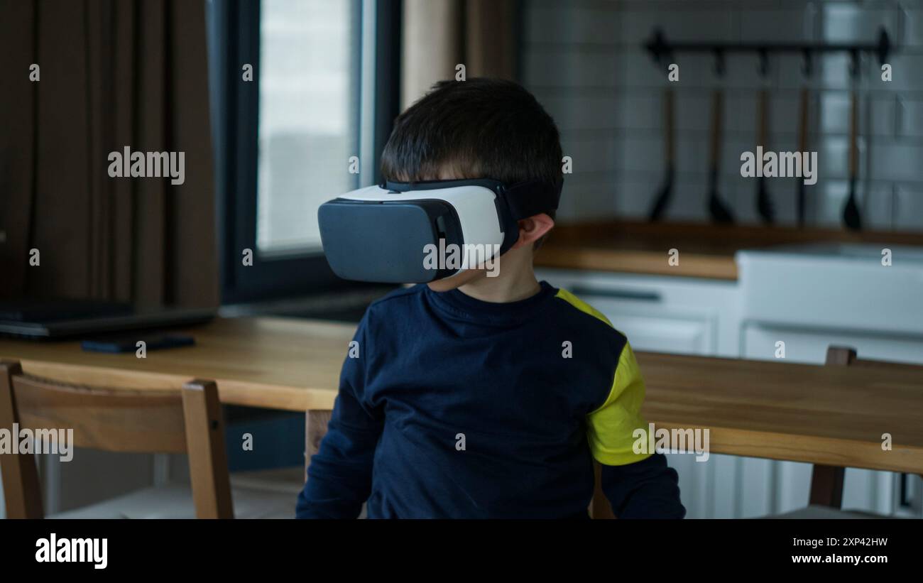 A young boy immersed in a virtual reality experience with a VR headset ...