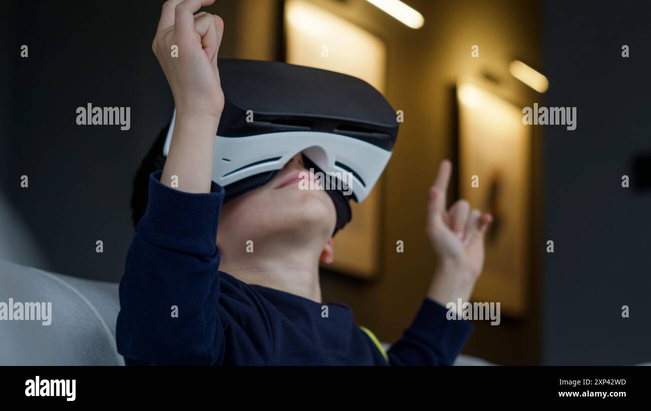 Young boy in a virtual reality experience with a VR headset. The ...