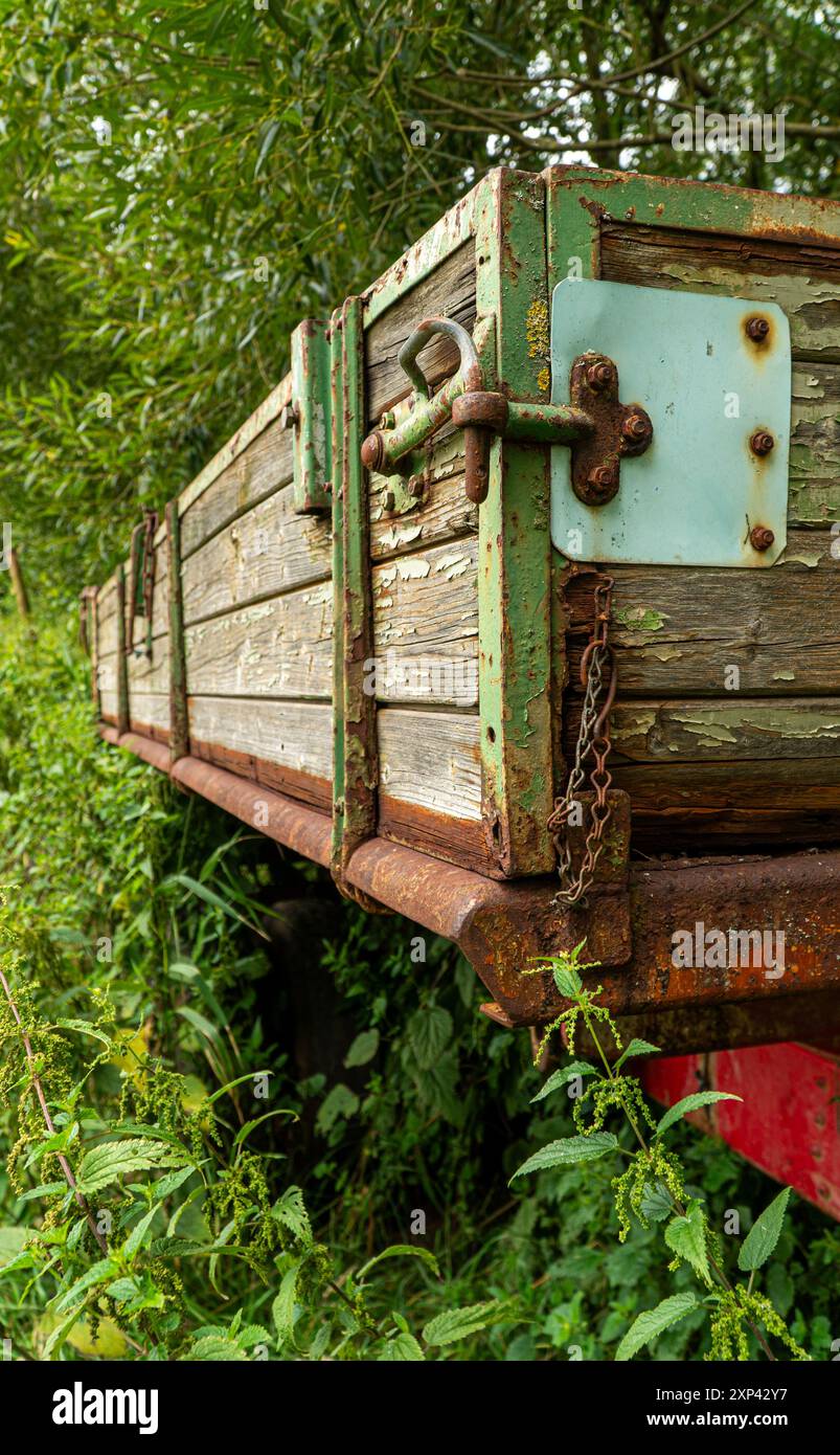 Old farm trailer in the bushes. Wooden sides. Museum object. Abandoned ...