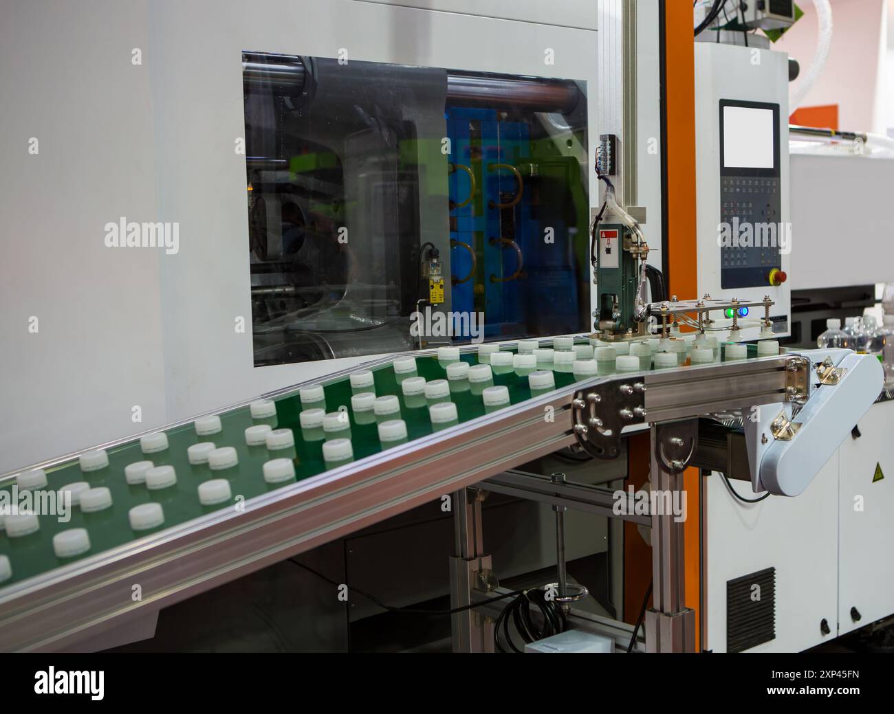 Plastic bottle caps on conveyor belt from plastic injection molding ...