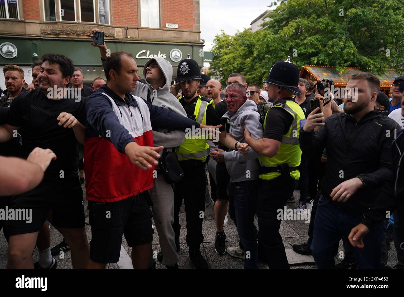 Police officers face protesters in Nottingham Market Square following ...