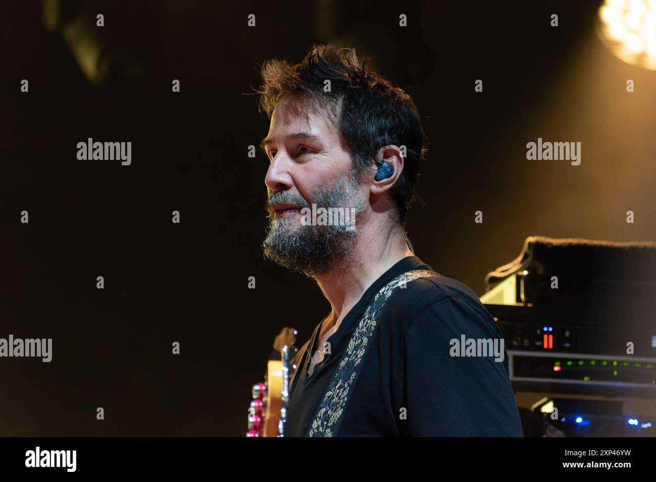 Headshot of actor Keanu Reeves playing bass guitar with his band ...