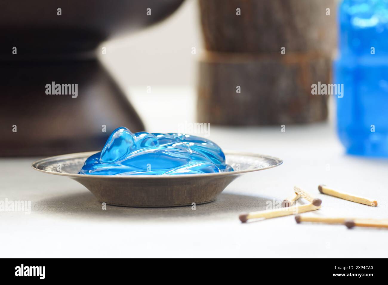 Chafing fuel gel poured into metal dish with matchsticks, blue chafer ...