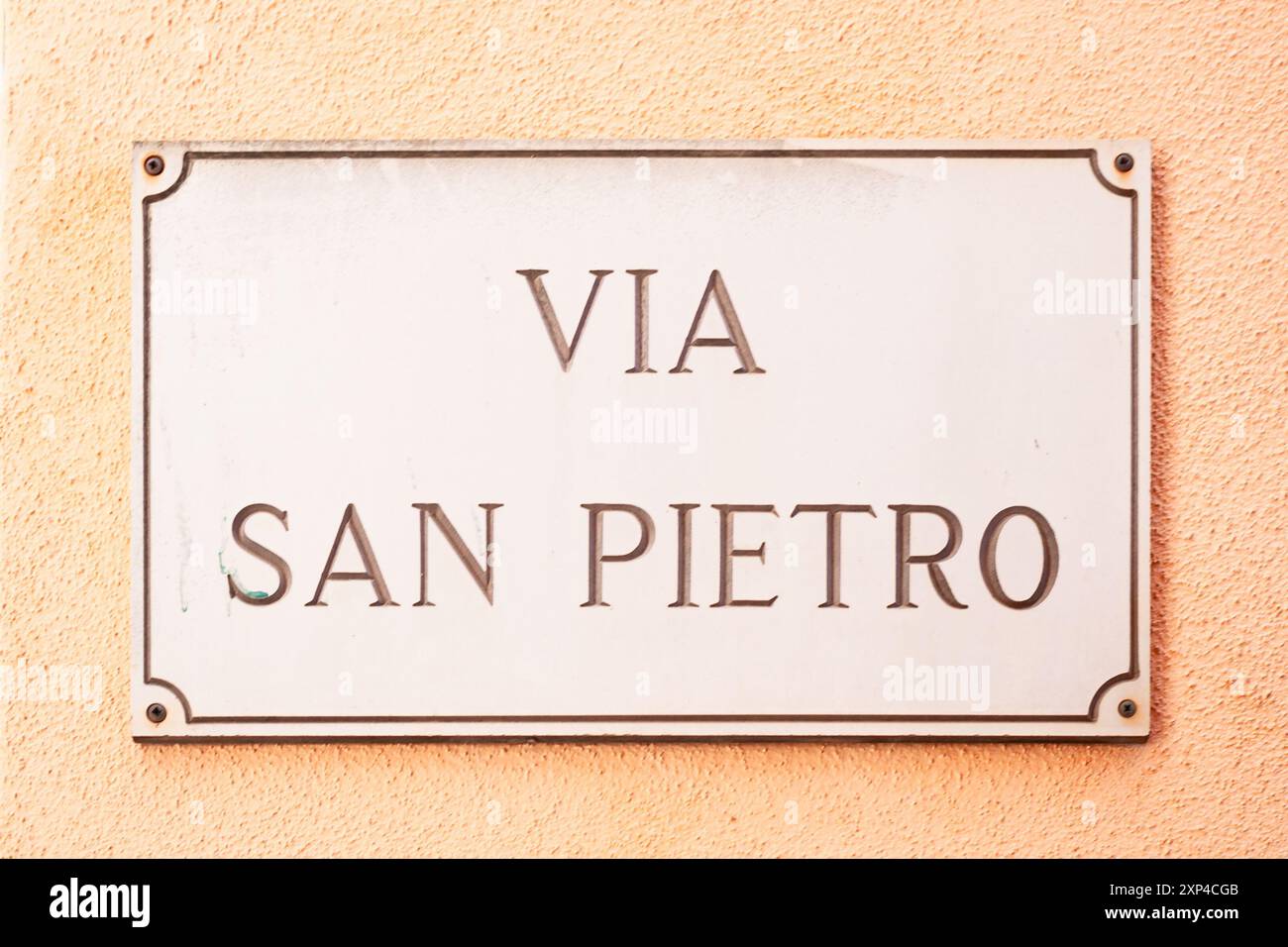 Decorative street sign 'Via San Pietro' on a wall in a street in a ...