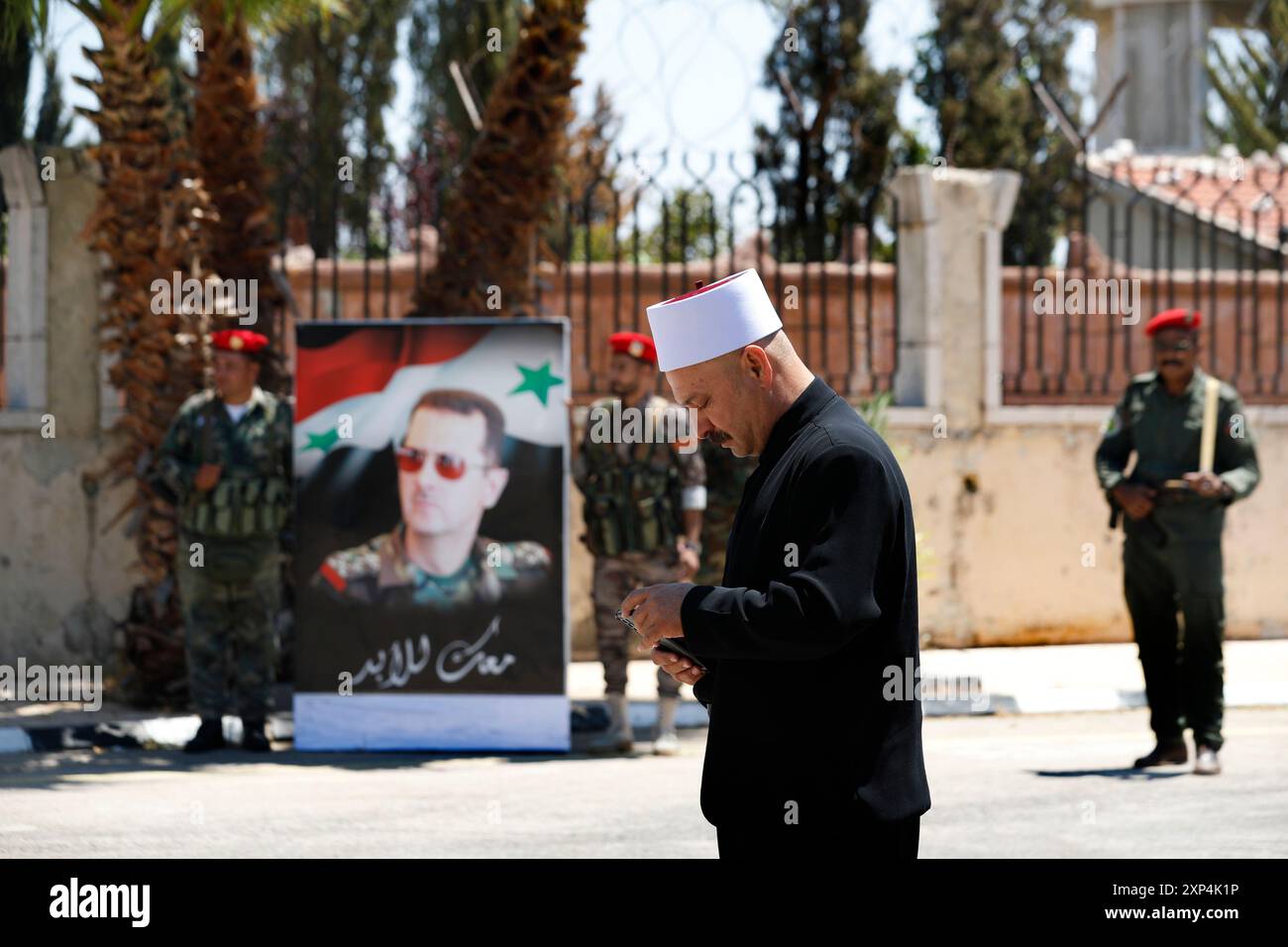 A Syrian Druze sheikh checks his mobile phone in front of Syrian ...