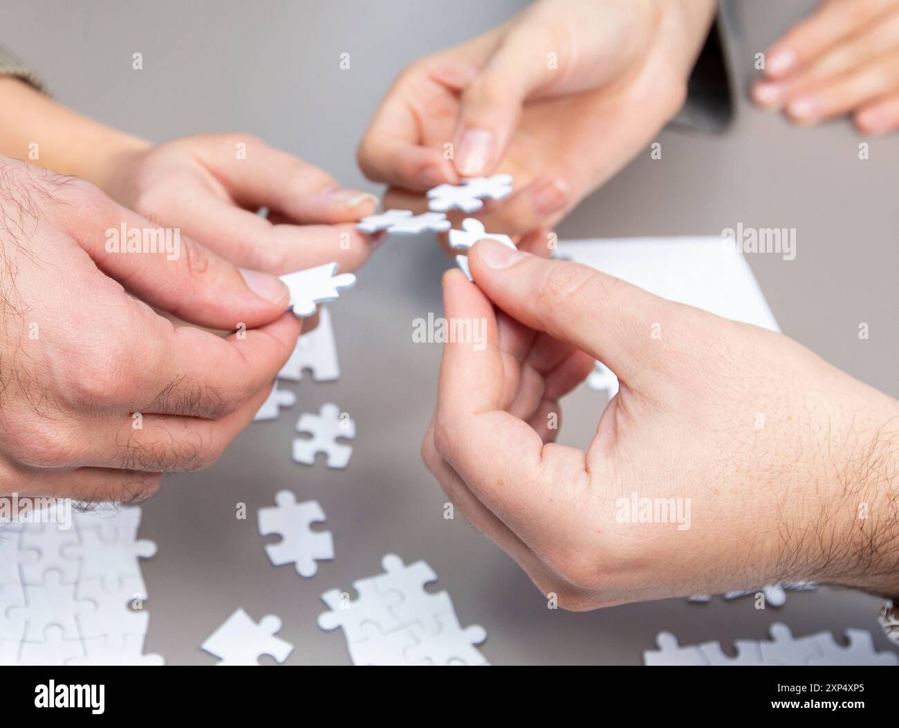 A group of people are working together to solve a jigsaw puzzle Stock ...