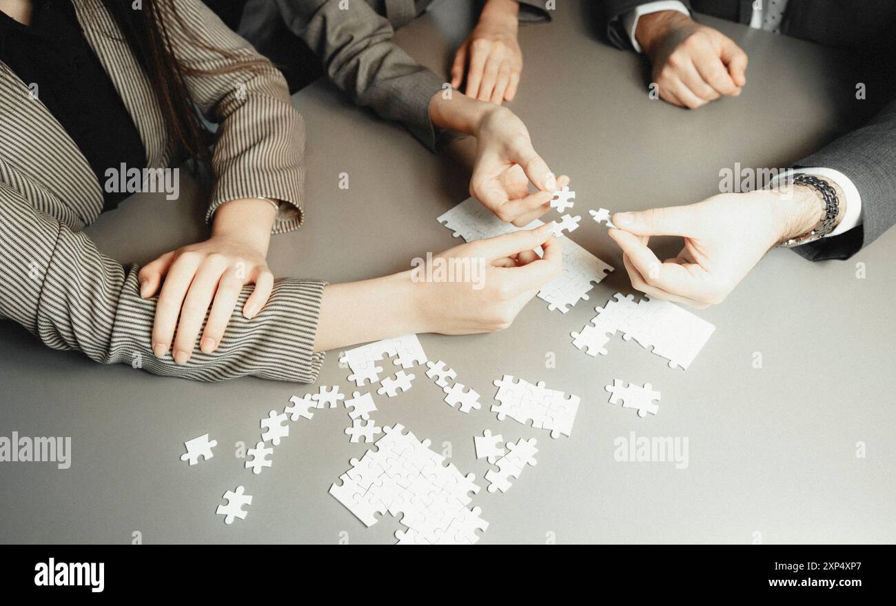 A group of people are working together to solve a jigsaw puzzle Stock ...