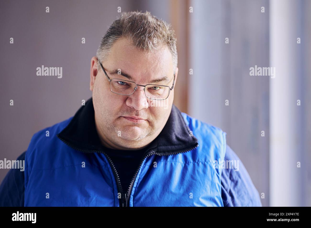 Frowning look from under eyebrows, large chubby-cheeked Caucasian man ...