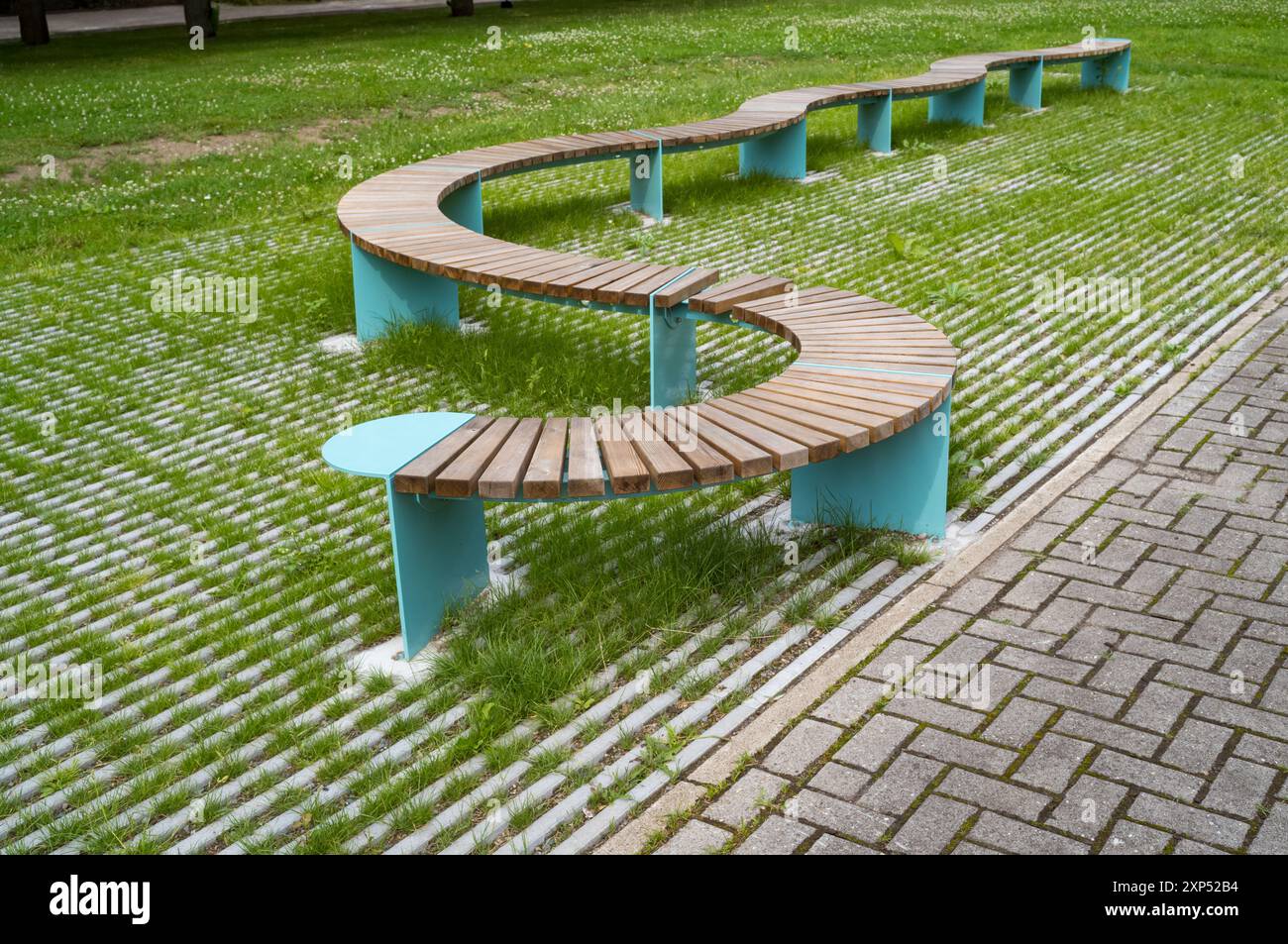 Modern wooden serpentine park bench Stock Photo - Alamy