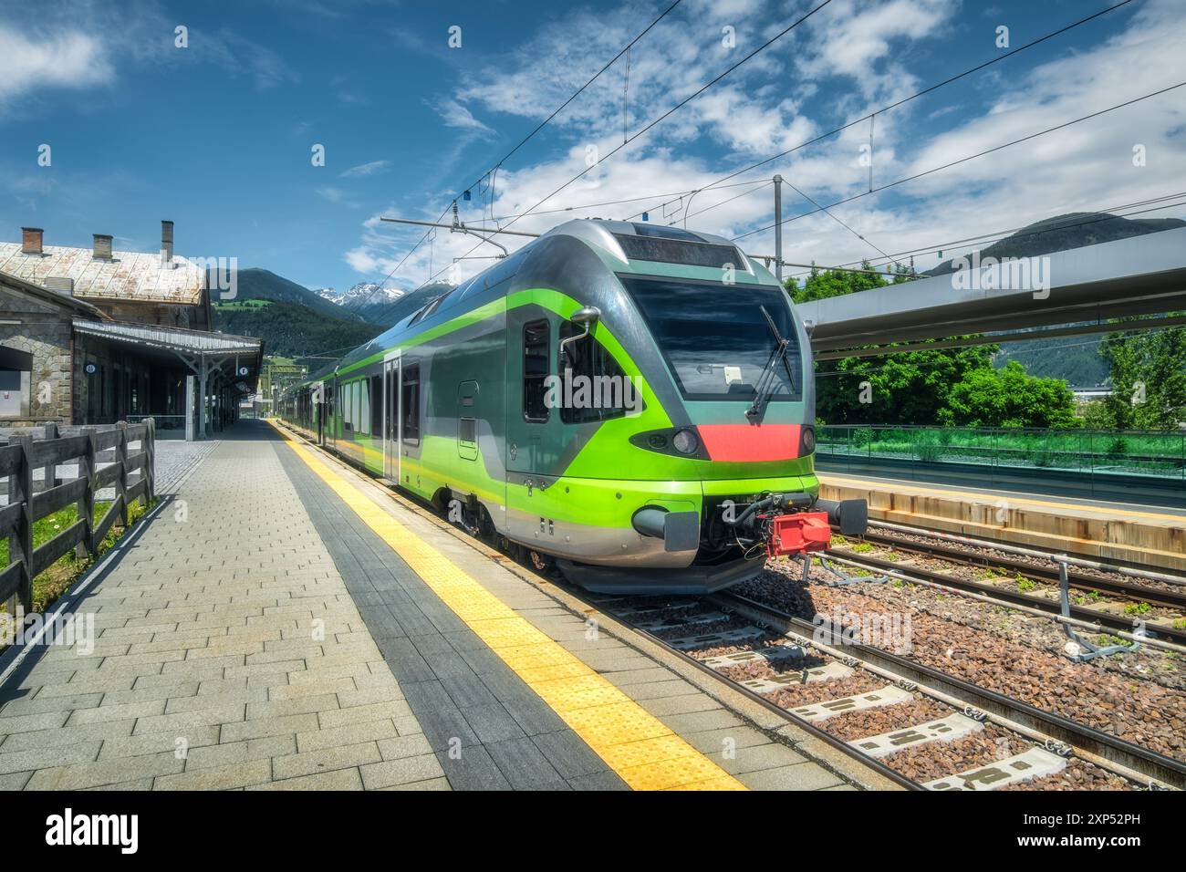 High-speed green passenger train at railway station platform Stock ...