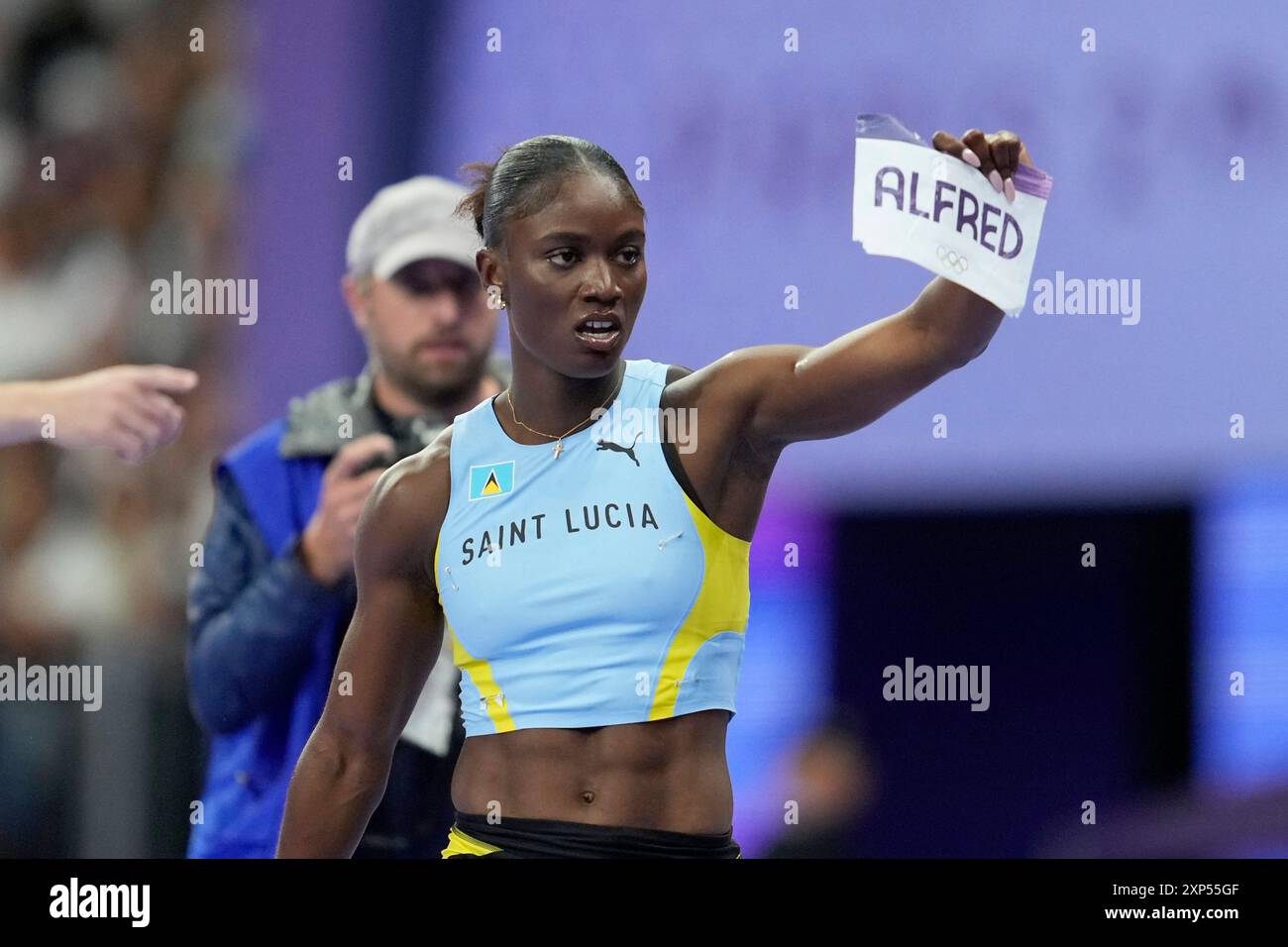 Julien Alfred, of Saint Lucia, holds up her name tag after winning the ...