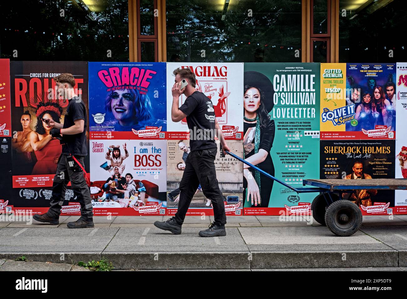 Edinbrugh Fringe staff walking by Fringe posters in George Square ...