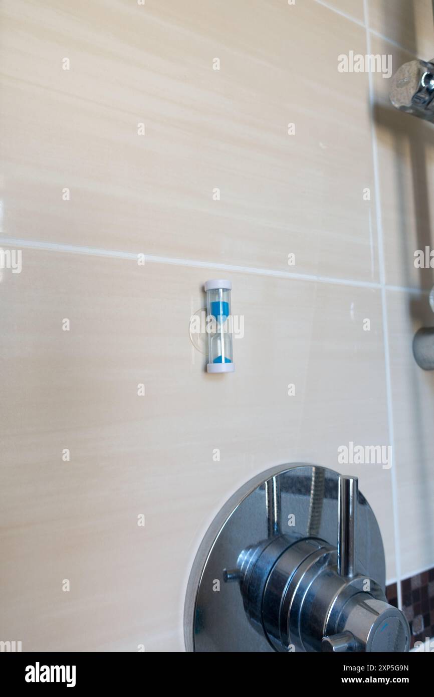 Shower timer on bathroom tiled wall Stock Photo - Alamy