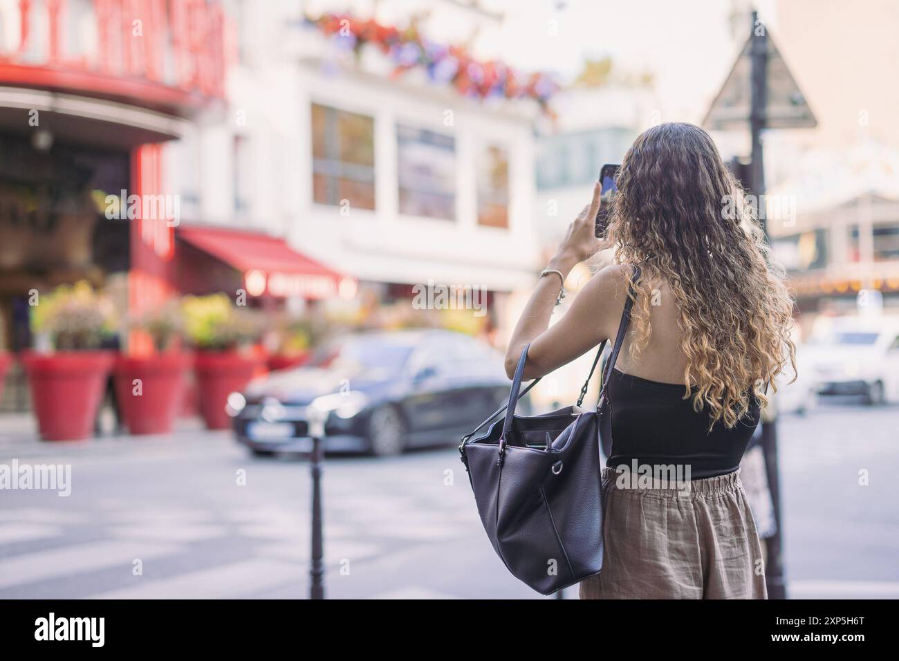 Unknown woman photographing around the famous Moulin Rouge landmark in ...
