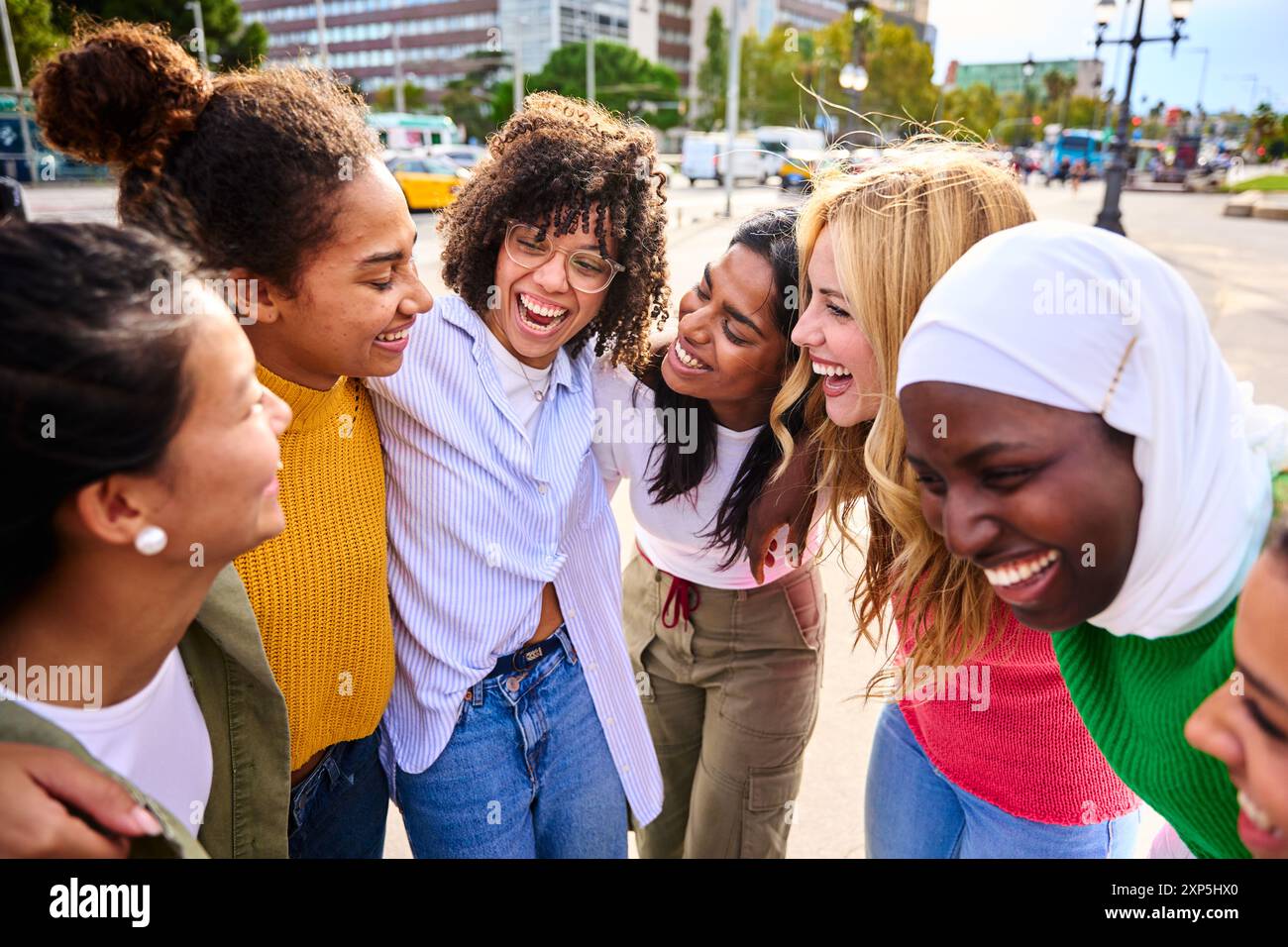 Group of multicultural young only women standing hugging in circle ...
